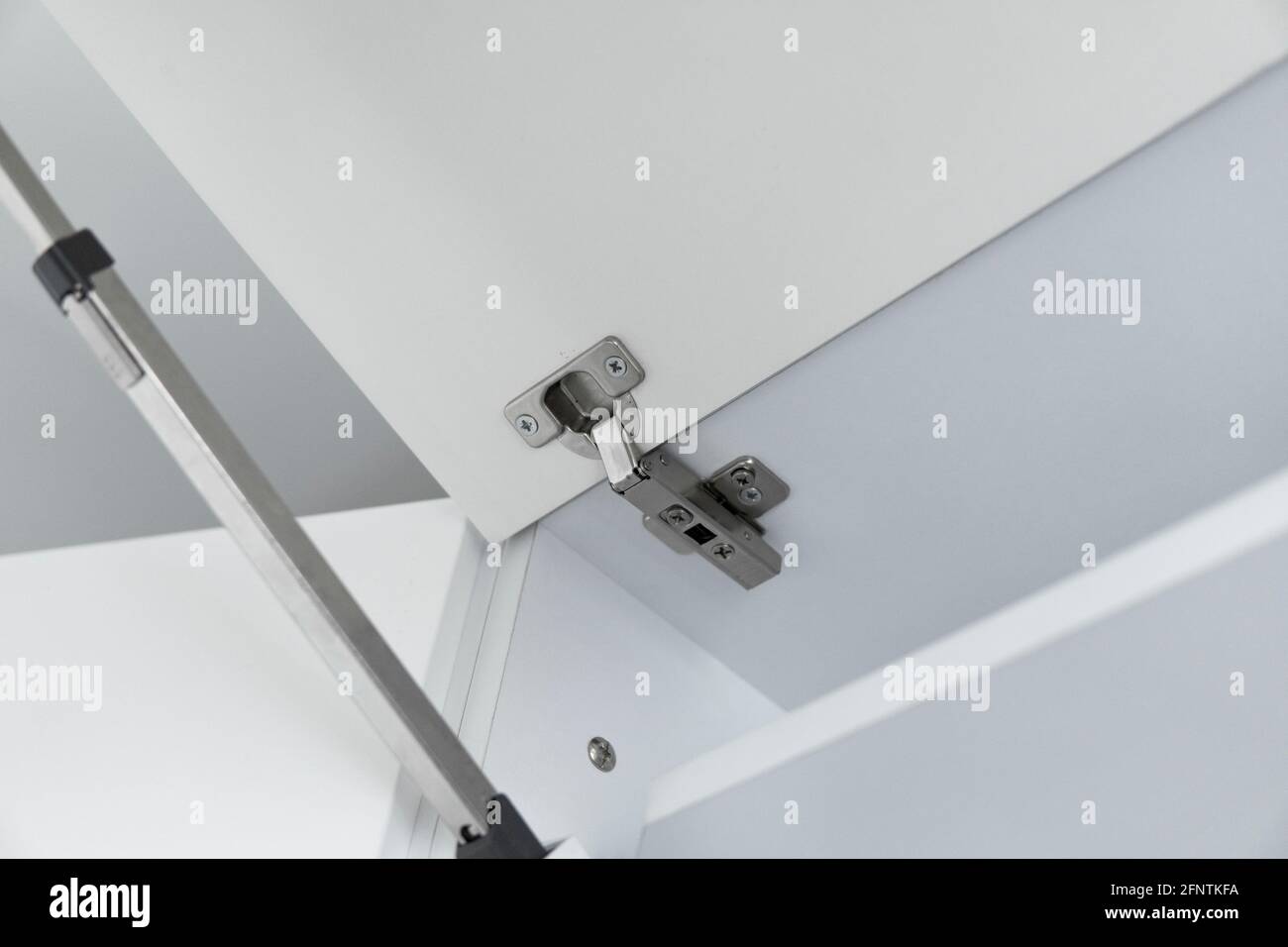 Metallic loop installed in a kitchen cabinet from a white chipboard ...