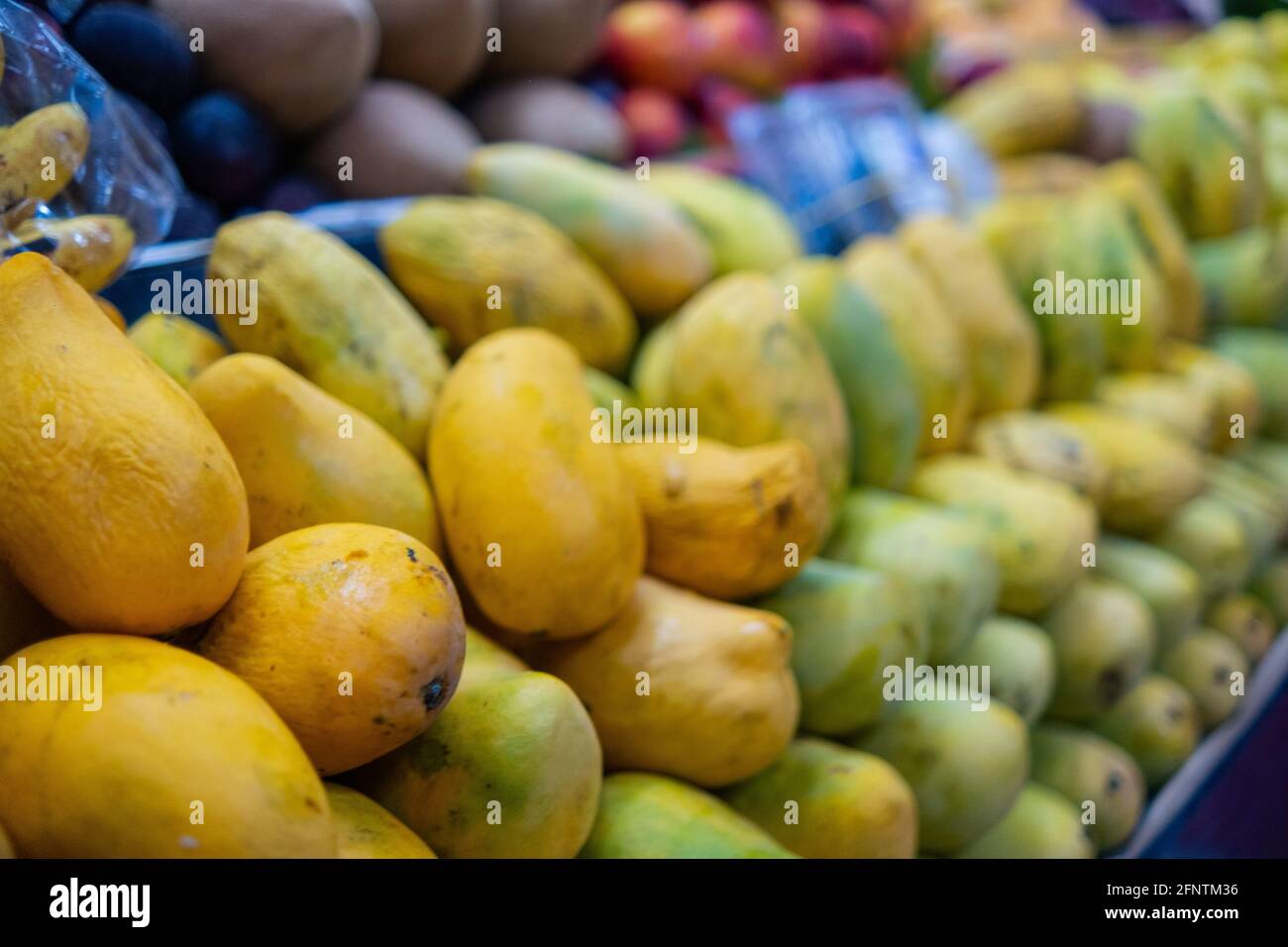 Colorful fruit stand with mangoes, small bananas, and more Stock Photo ...