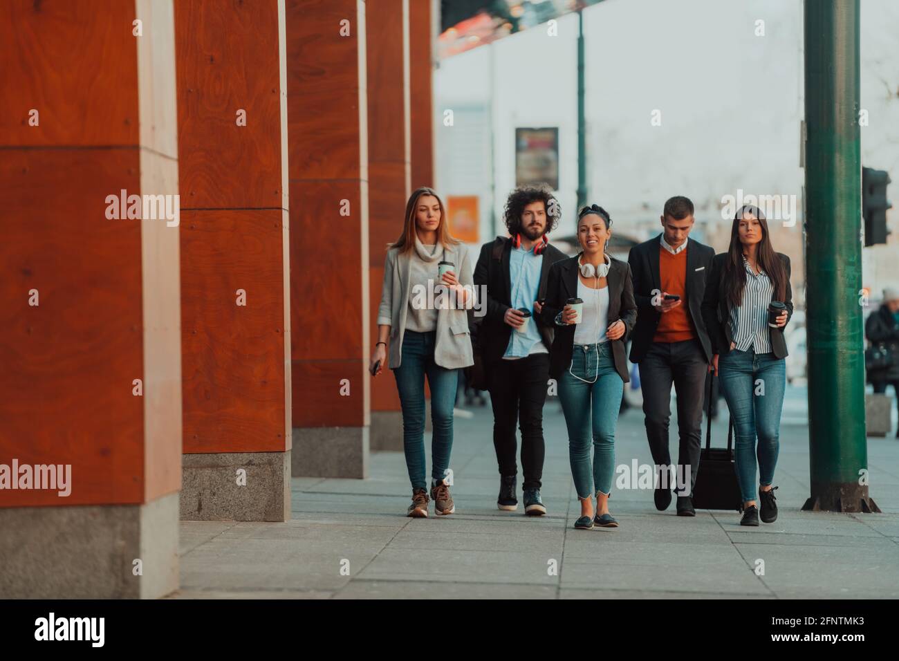 Business colleagues walking and talking on city streets Stock Photo - Alamy