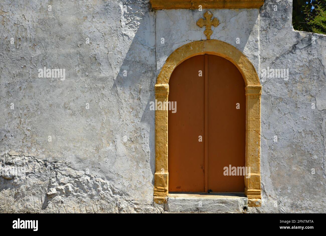 Traditional Greek Orthodox church arched entrance door with ochre trim ...