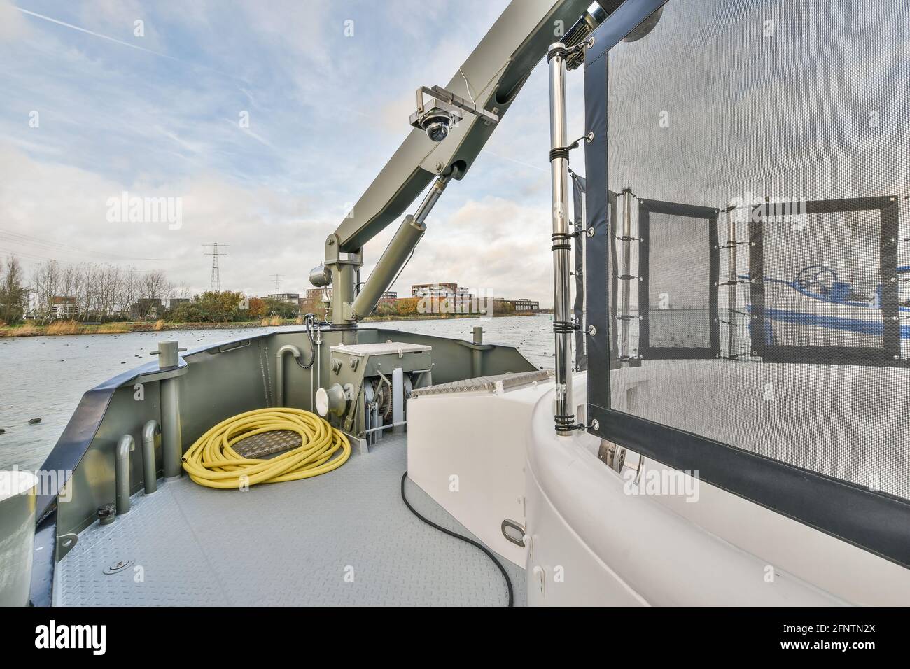 Deck of modern industrial ship floating on river water against cloudy ...