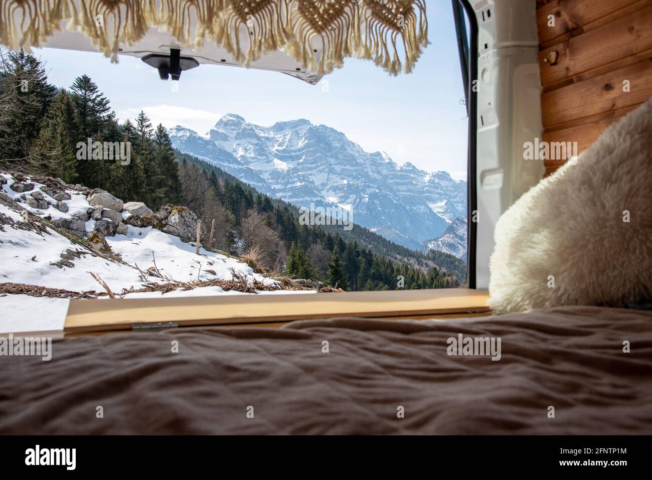 View of a winter alpine mountain through the window of a campervan ...