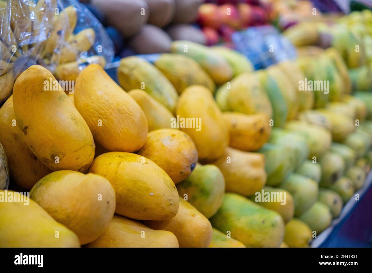 Colorful fruit stand with mangoes, small bananas, and more Stock Photo ...