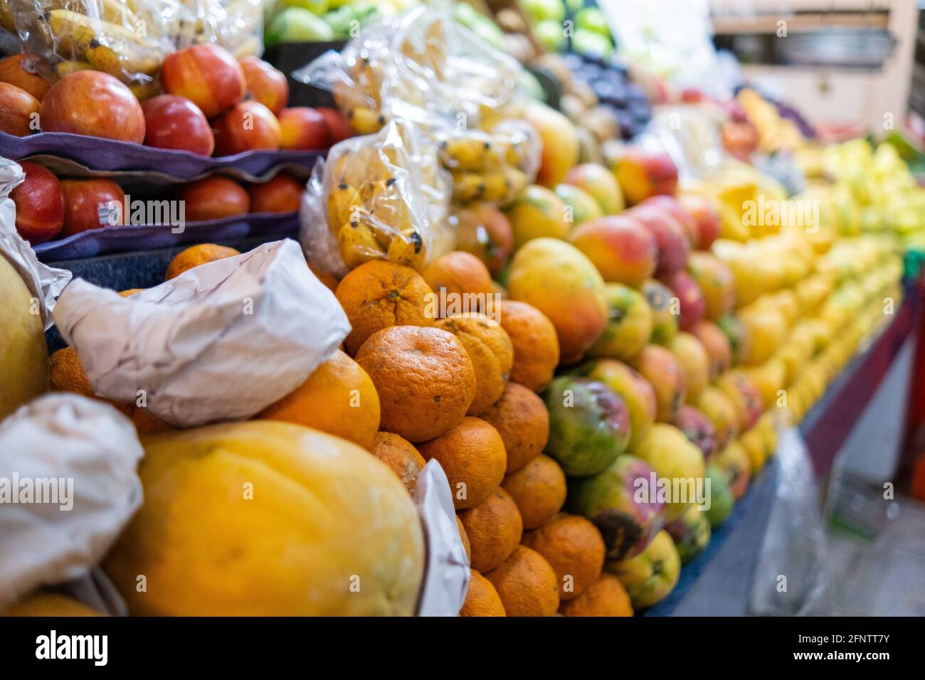 Colorful fruit stand with papayas, tangerines, apples, mangoes and more ...
