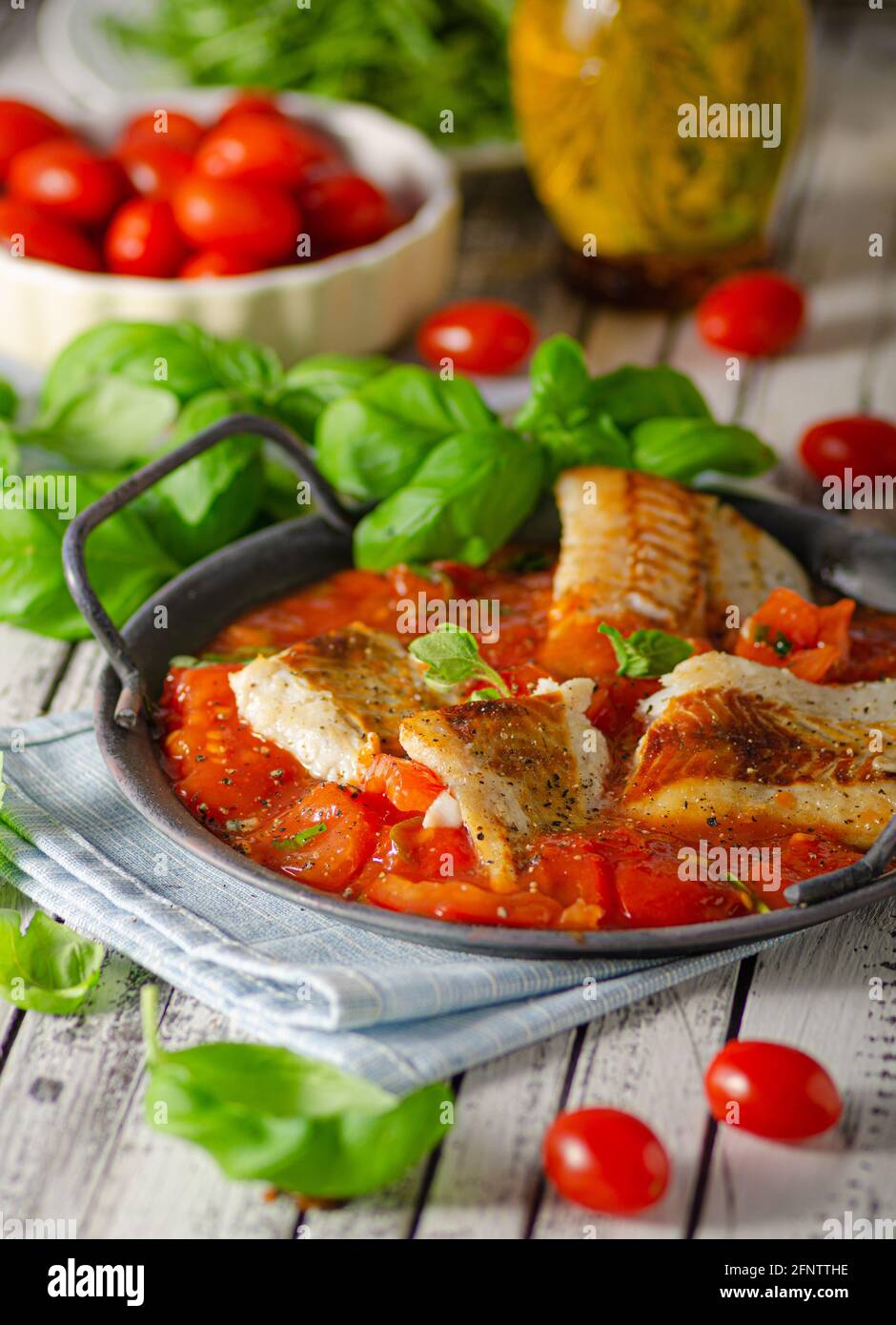 Grilled fish in tomato sauce with basil and herbs Stock Photo - Alamy