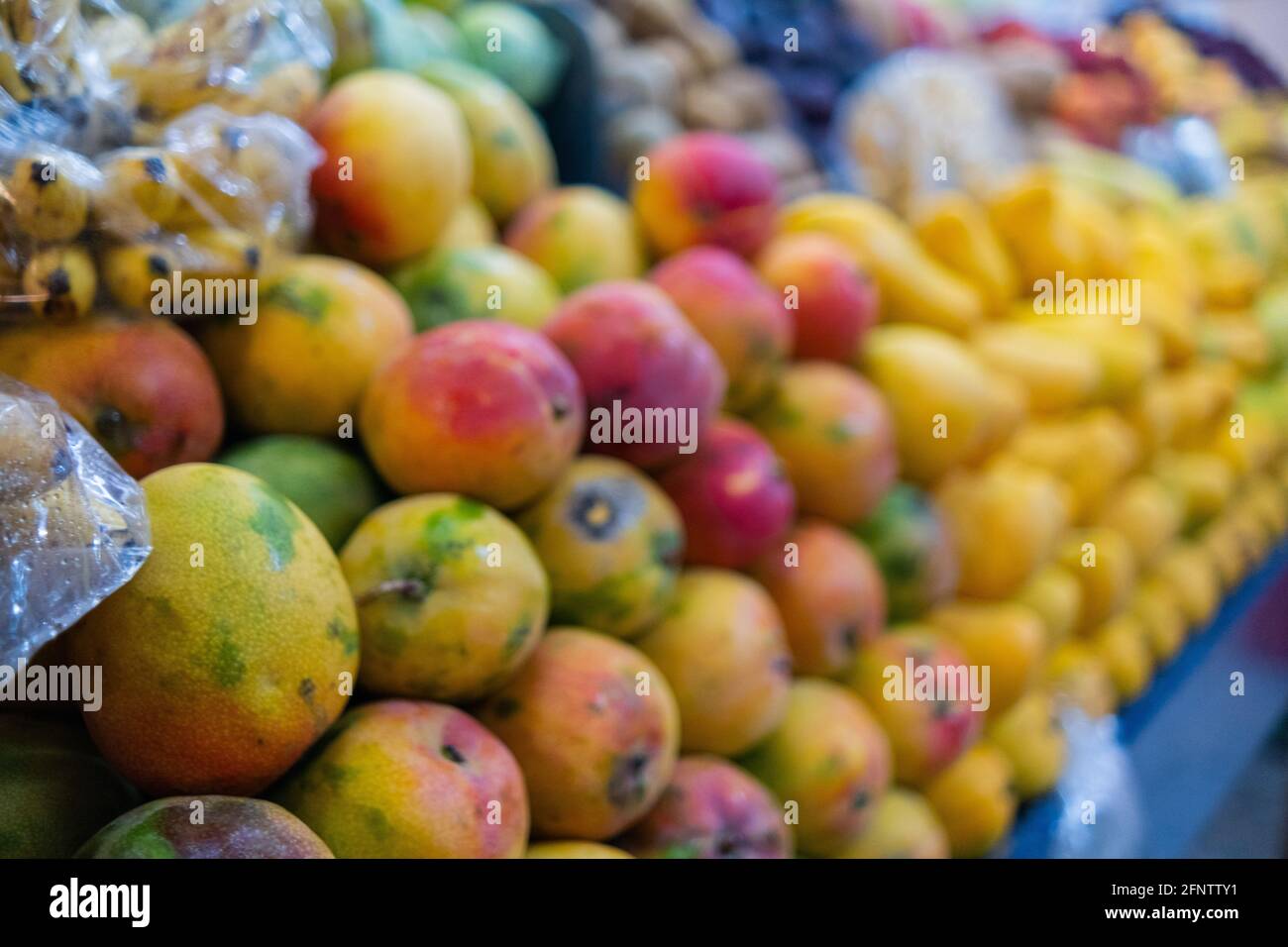 Colorful fruit stand with mangoes, small bananas, and more Stock Photo ...