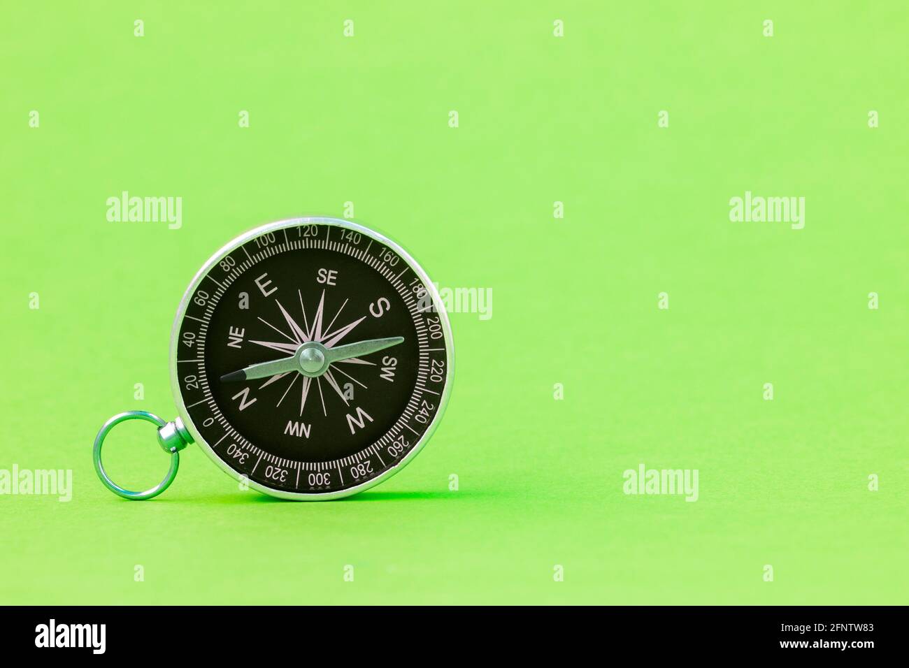 Black compass on the green background. Copy space Stock Photo - Alamy