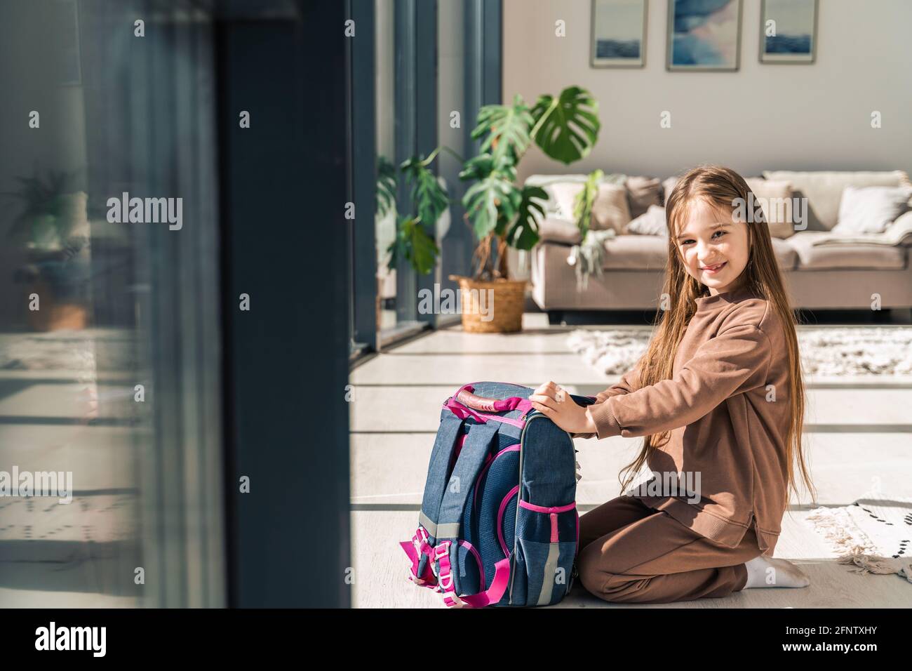 Little girl prepares school backpack Stock Photo - Alamy