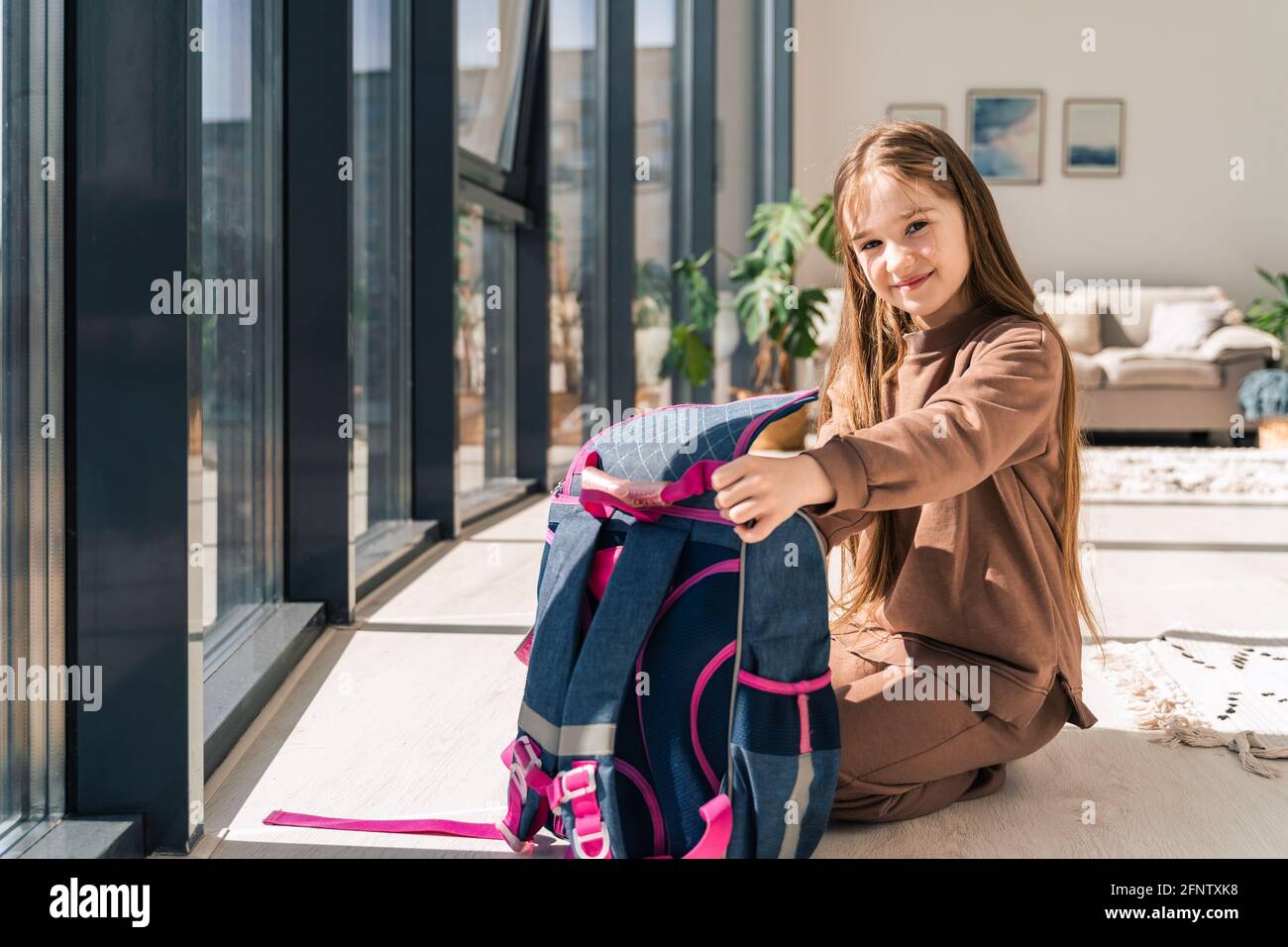 Little girl prepares school backpack Stock Photo - Alamy