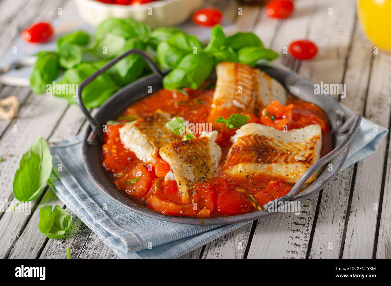 Grilled fish in tomato sauce with basil and herbs Stock Photo - Alamy