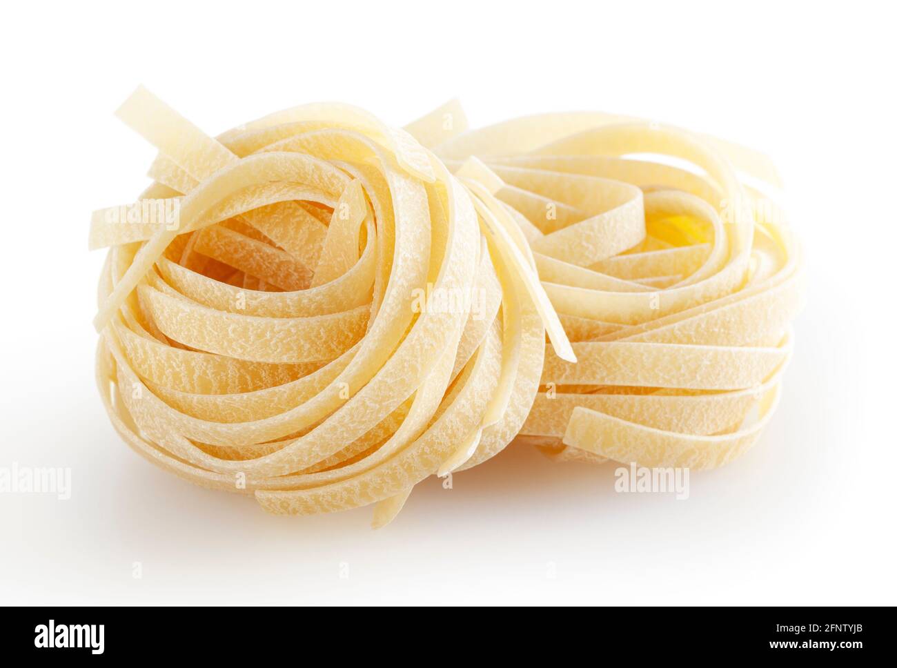 Uncooked tagliatelle pasta isolated on white background with clipping ...
