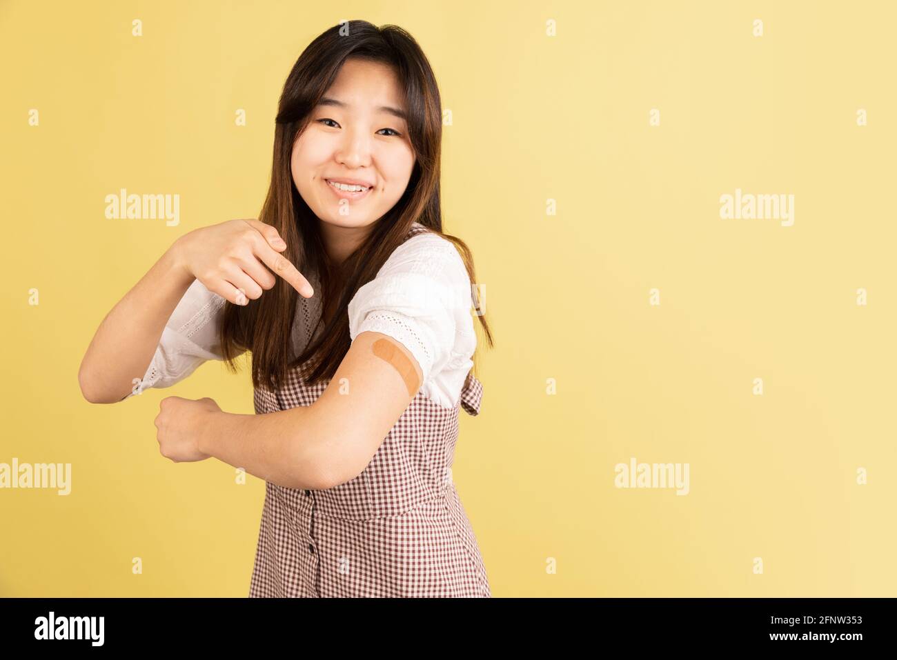 Asian young woman's portrait on yellow studio background. Concept of ...