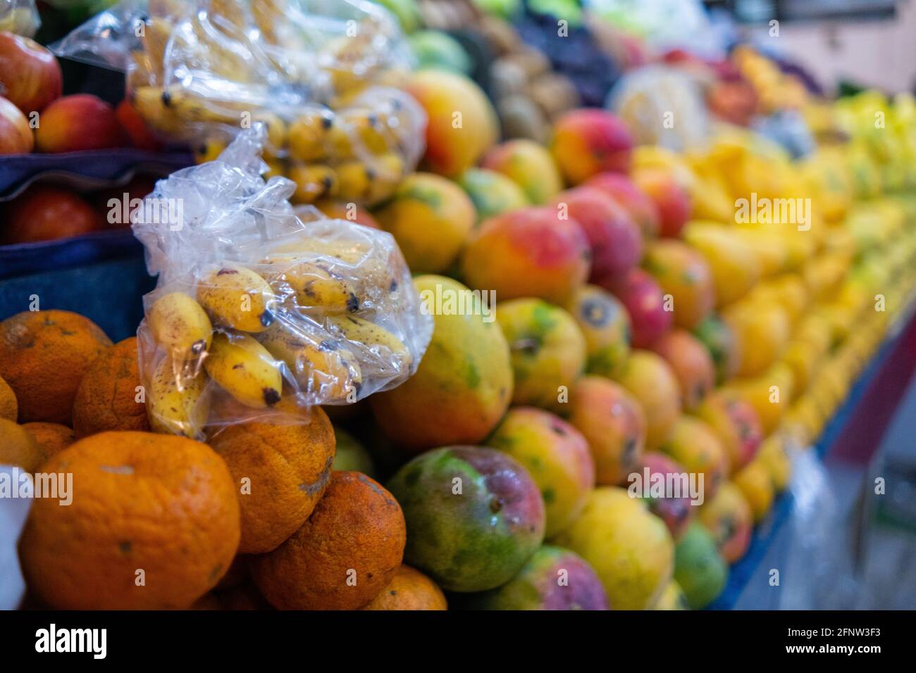 Colorful fruit stand with mangoes, small bananas, and more Stock Photo ...