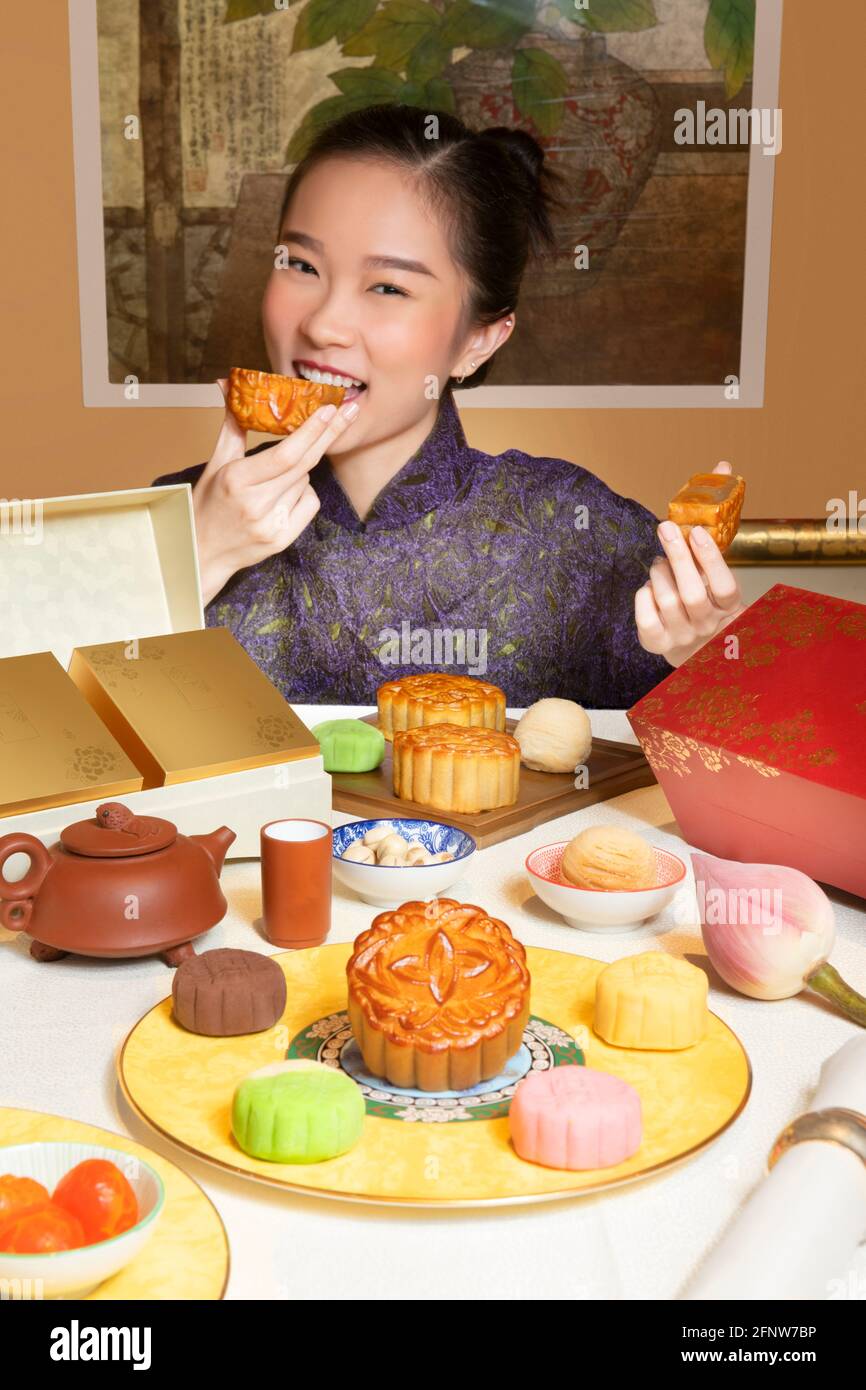 Asian young woman eating mooncake Stock Photo - Alamy