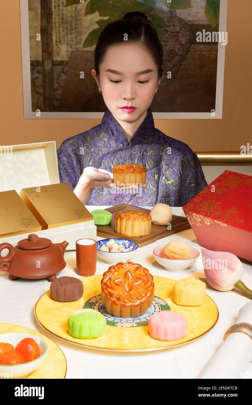Asian young woman eating mooncake Stock Photo - Alamy