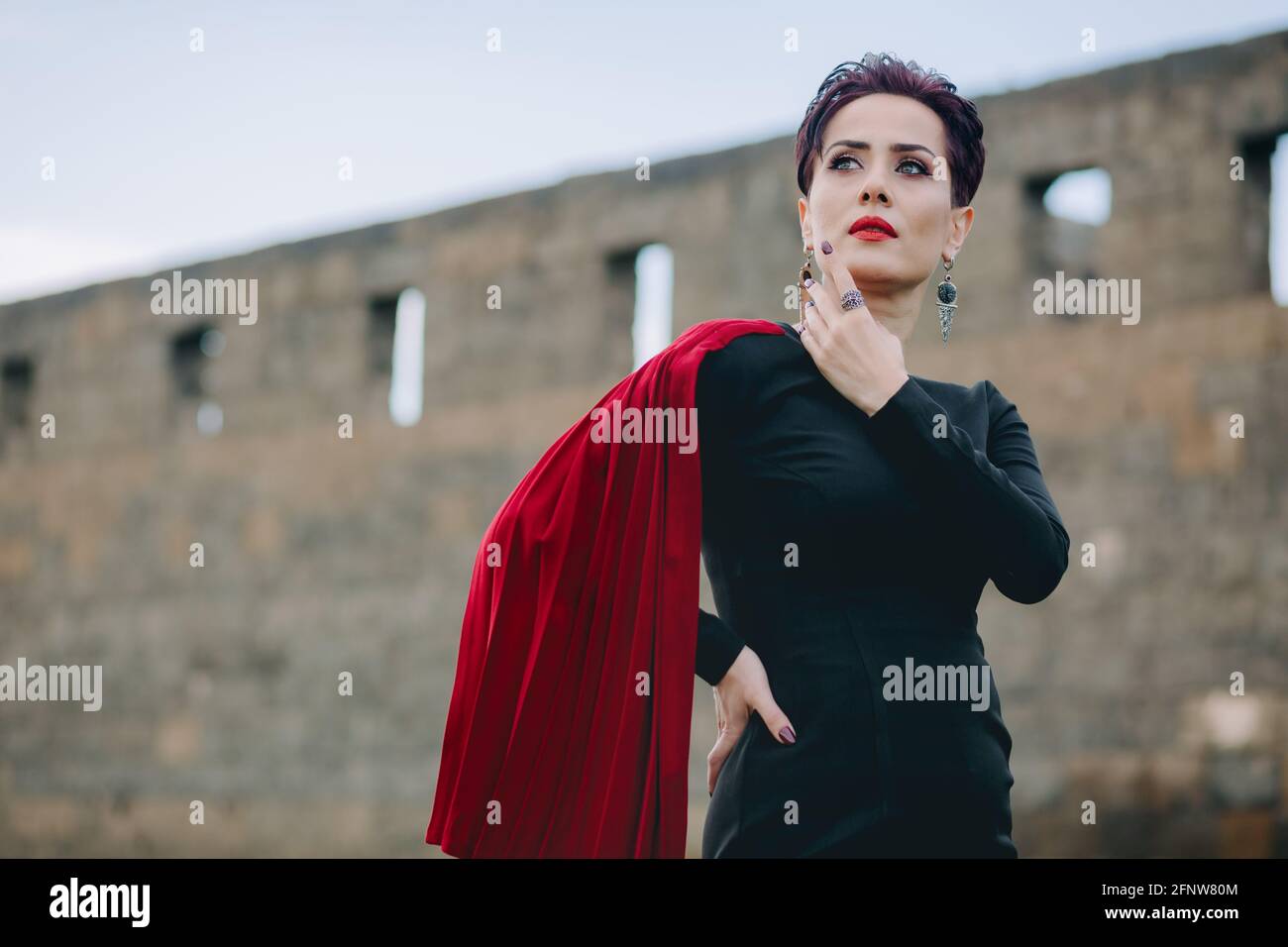 Low angle view of attractive and gorgeous woman with red mantle and ...
