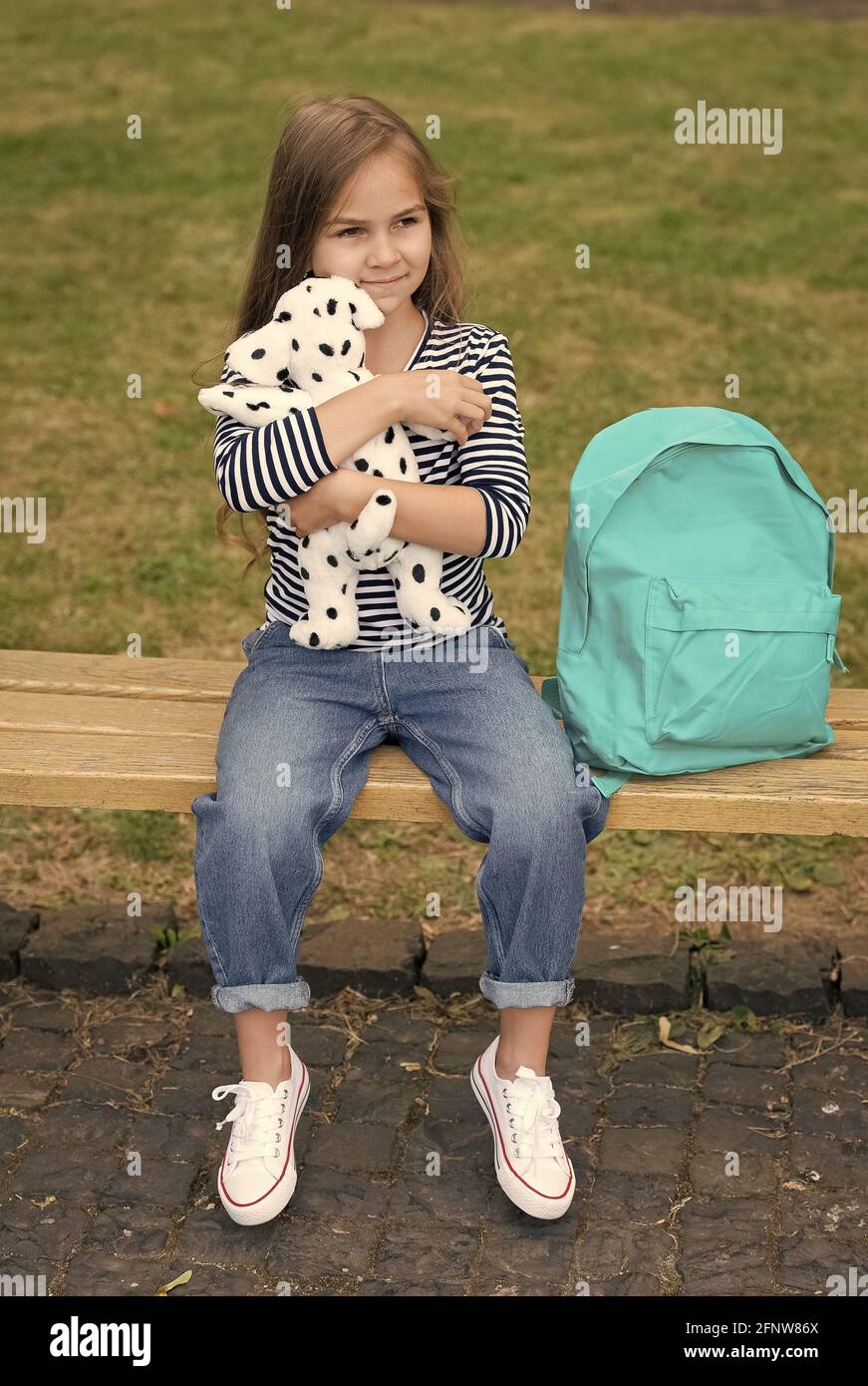 Biggest joy is playing. Happy kid play with toy dog outdoors. Childhood ...