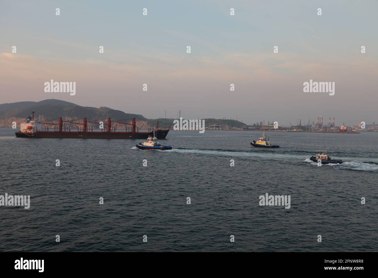 cargo vessel and tug boats Stock Photo - Alamy