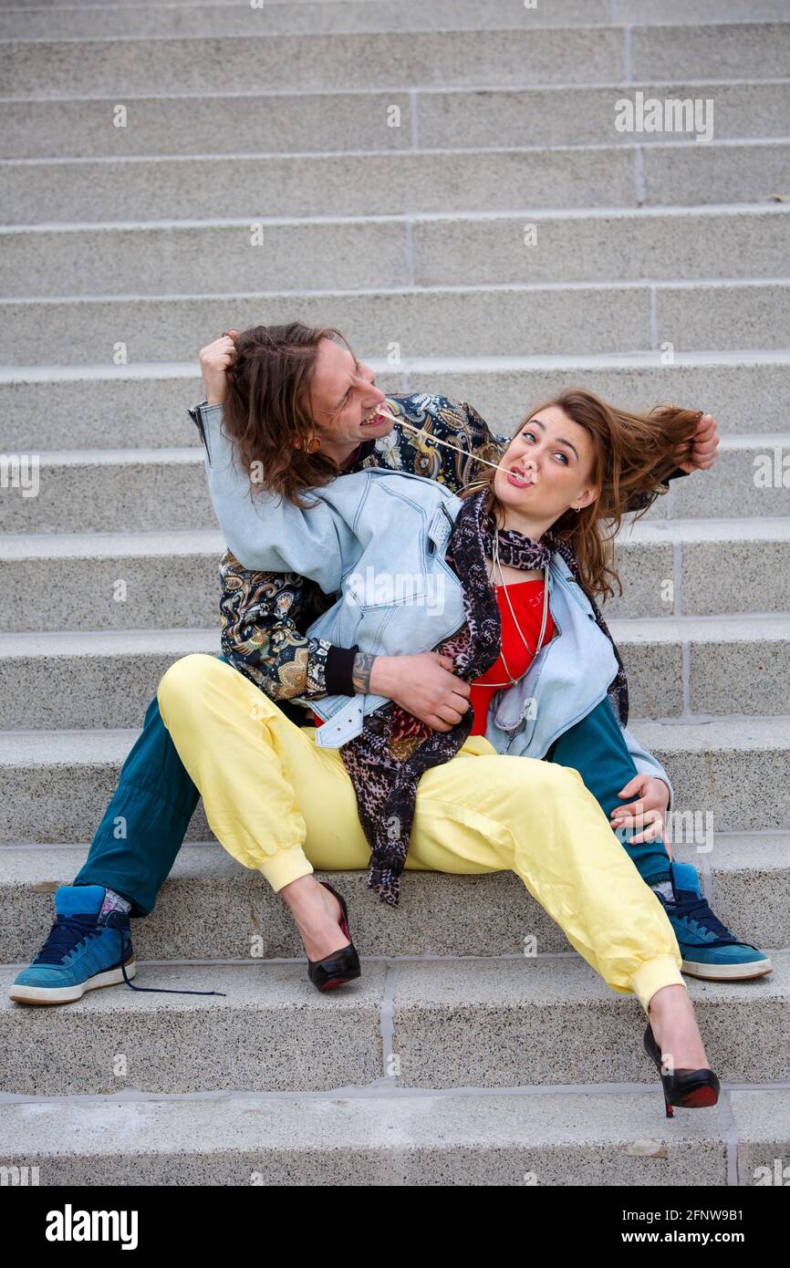 young couple sitting on steps and playing with chewing gum Stock Photo ...