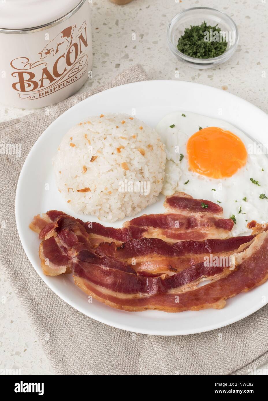 Bright breakfast meal with bacon, sunny side up, and garlic rice Stock ...