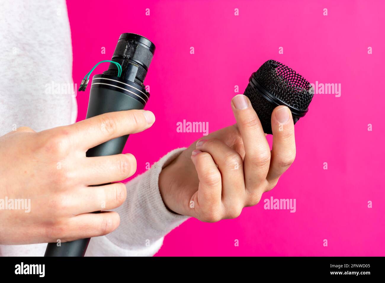 Female hands are holding a broken microphone. Black broken microphone ...