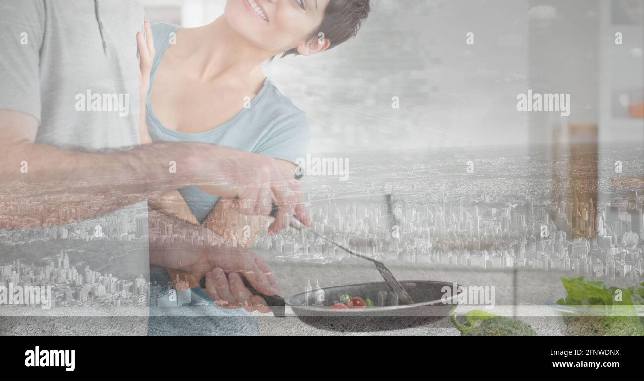 Composition of couple in love cooking in kitchen over cityscape Stock ...