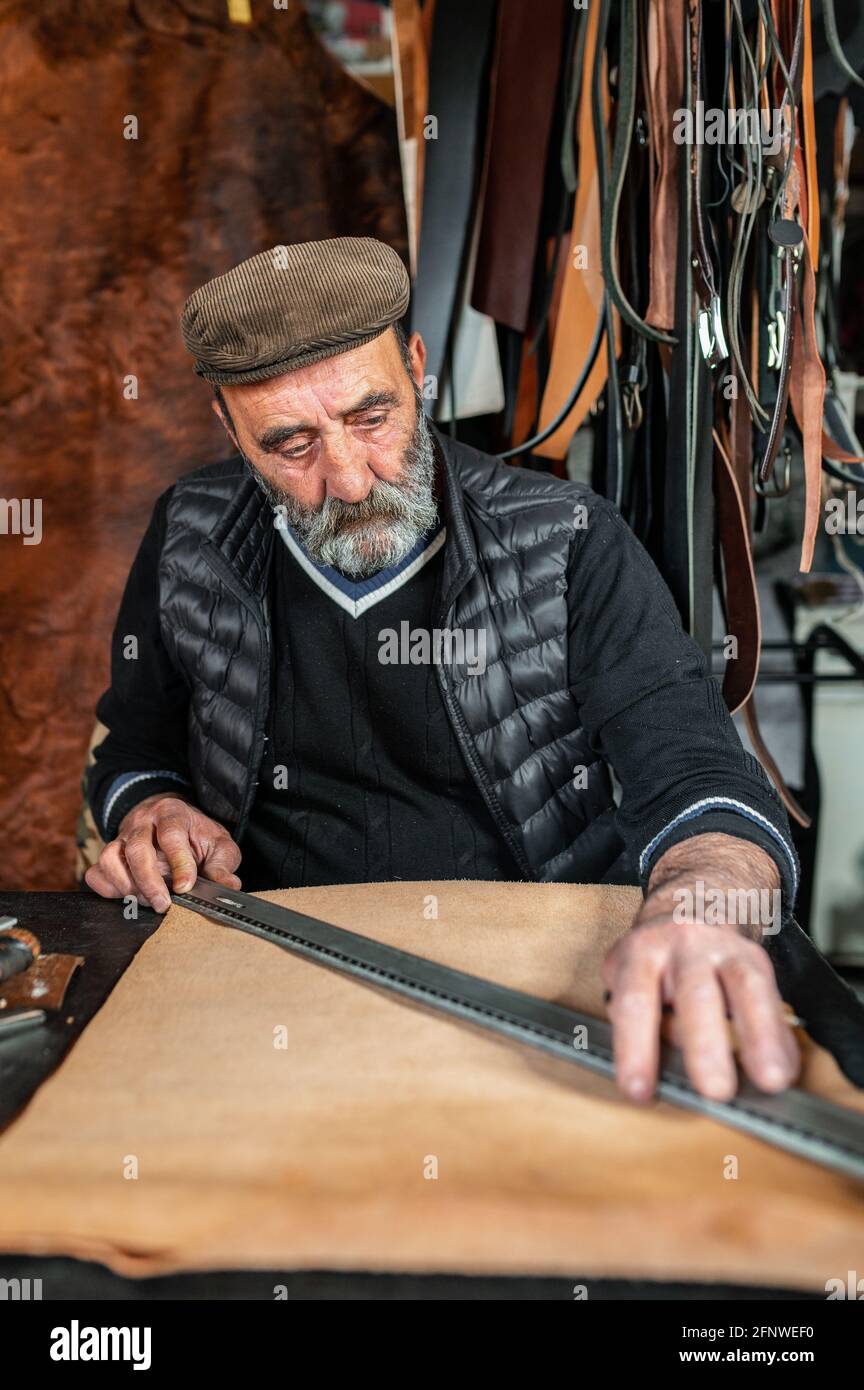 Vertical portrait of senior bearded craftsman measuring and working ...
