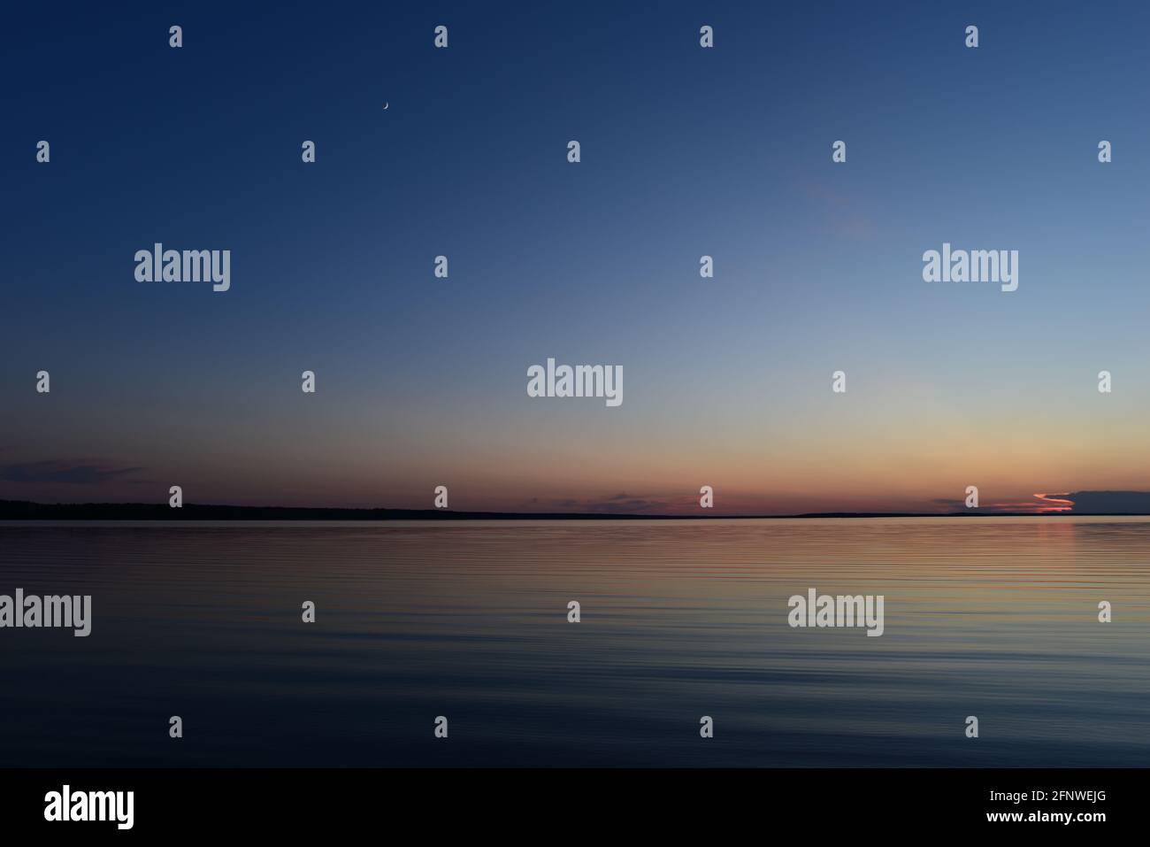 Twilight blue sky with a glow young moon Stock Photo - Alamy