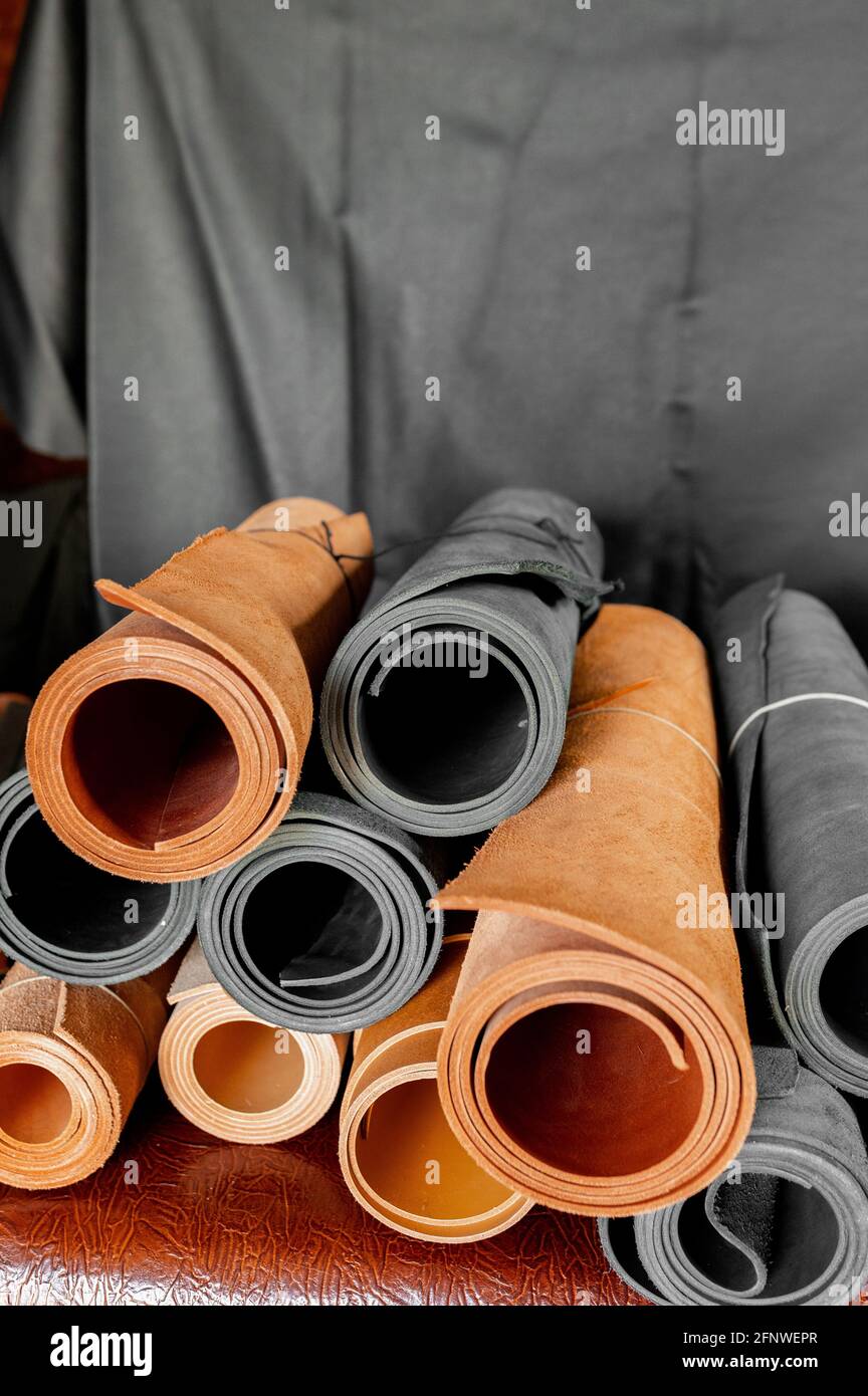 Vertical frame of brown and black textile genuine leather rolls. Stack ...