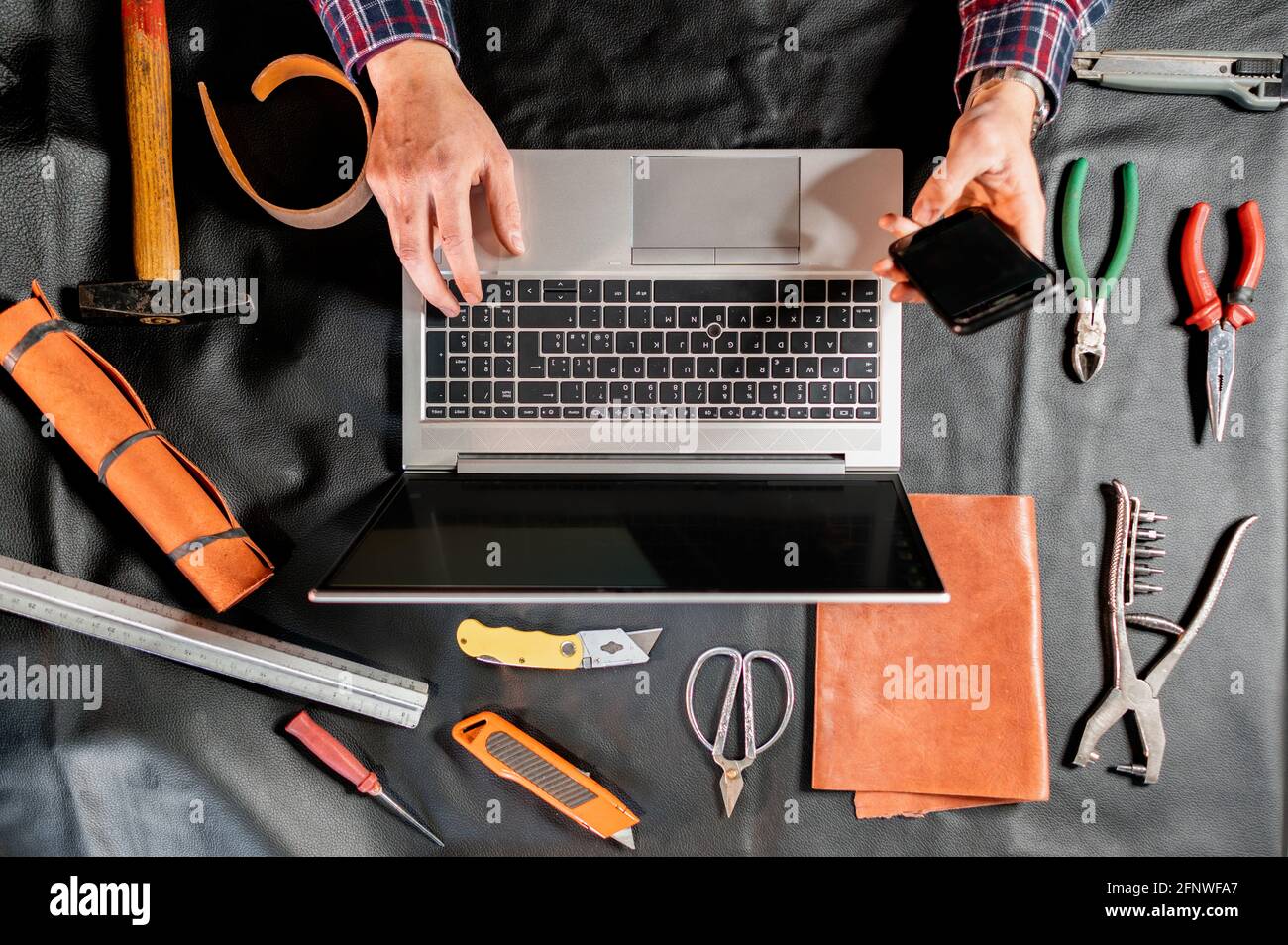 Top view unrecognizable man holding smartphone and using computer ...