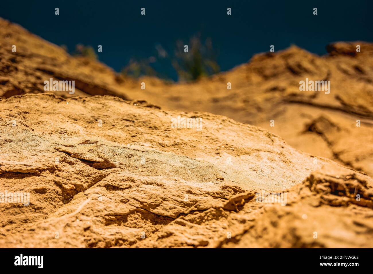 Sand cliffs against the blue sky. Bright sand texture. The rough and ...