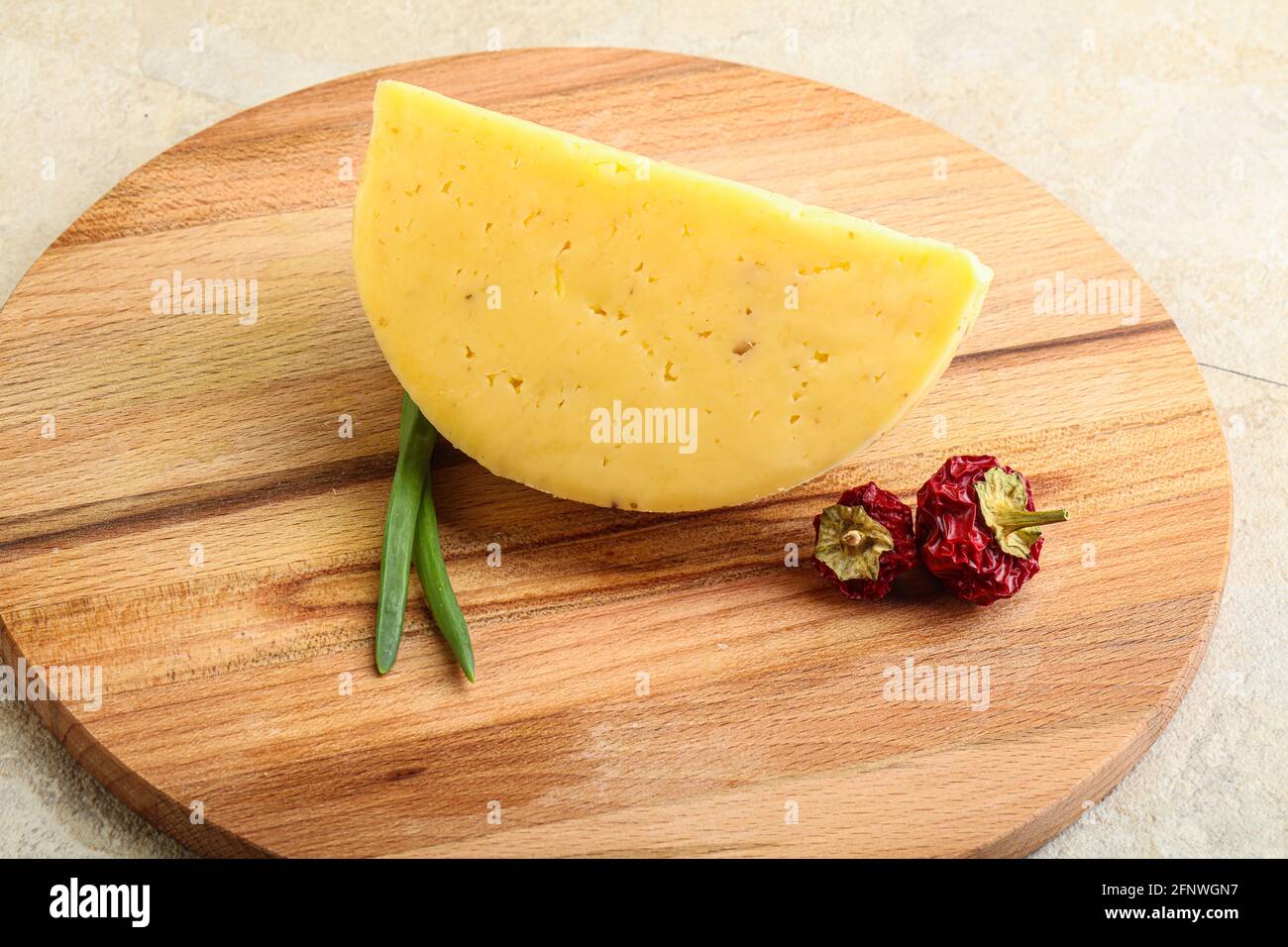 Hard cheese brick with walnut over board Stock Photo - Alamy