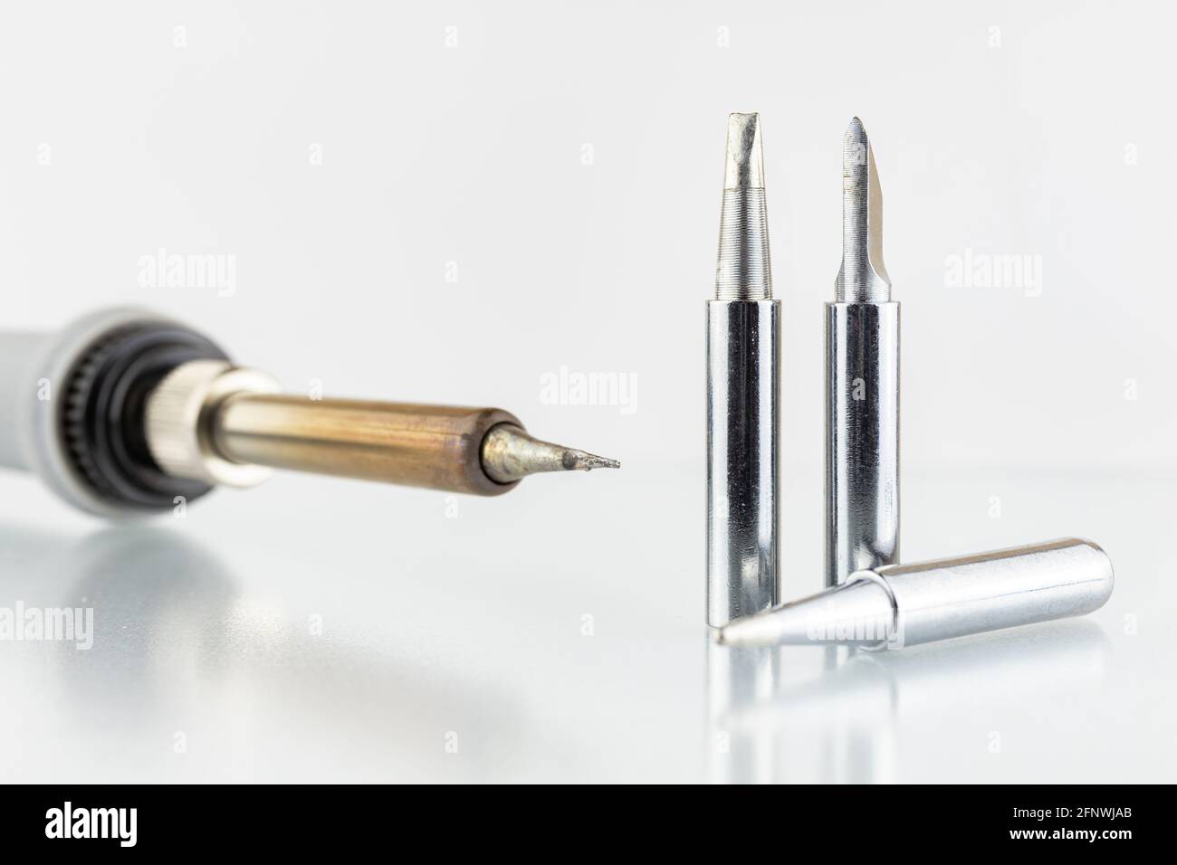 Soldering iron and tips close up photo on glass table background Stock ...