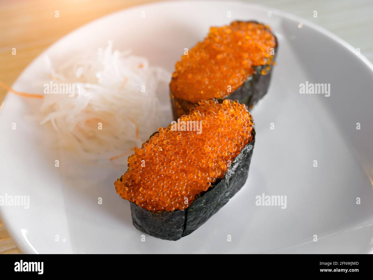Gunkan sushi from tobiko flying fish roe in white plate with indoor low ...