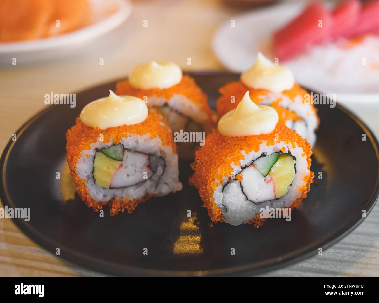 California roll and cut served in black plate with indoor low lighting ...