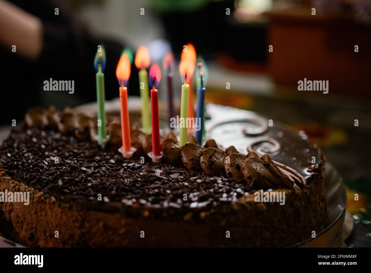 Chocolate birthday cake with candles, lighting candles on the cake ...