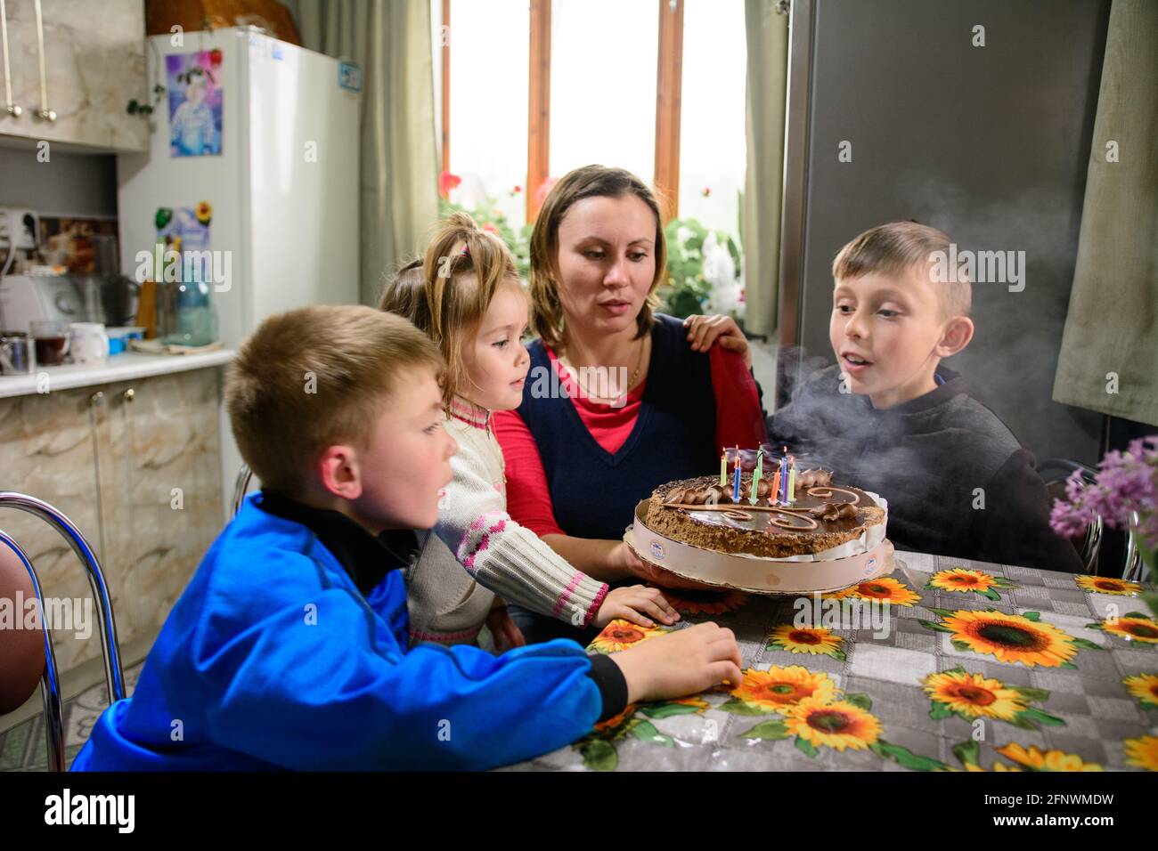 Children blow out candles on a name cake, a delicious dessert for a ...