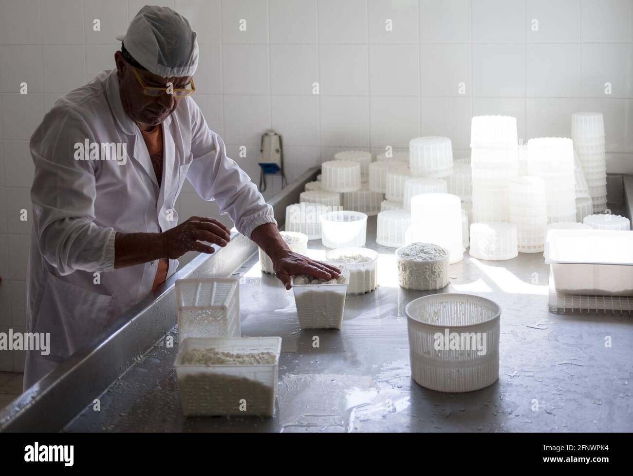 Man making ricotta cheese in a small cheese factory in Italy Stock ...