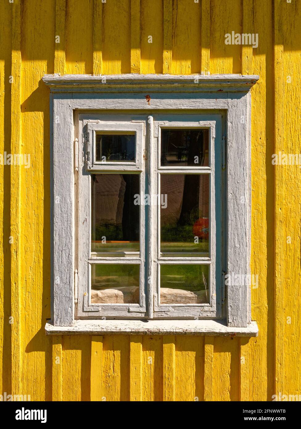 Old aged worn white window closeup exterior view wooden yellow house in ...