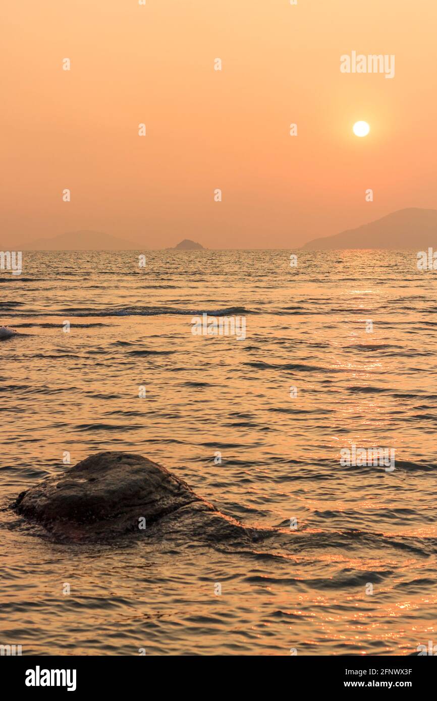 Beautiful sunset on the sea with rocks in Pui O, Hong Kong Stock Photo ...