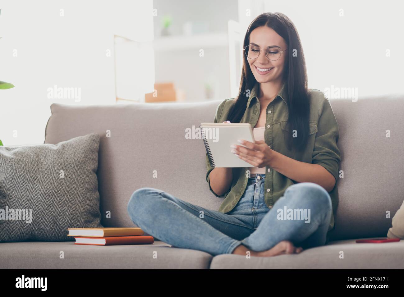 Portrait of charming cheerful focused girl sitting on divan lotus pose ...