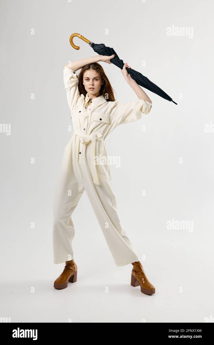 Woman in white overalls holding an umbrella above her head protection ...