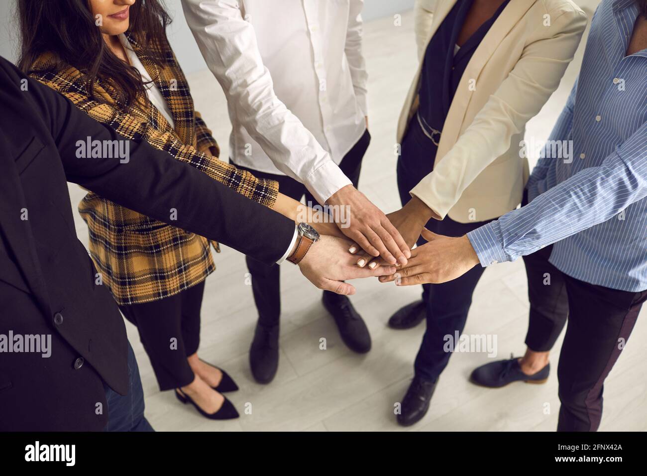 Multiethnic business team hands together stacking in circle midsection ...