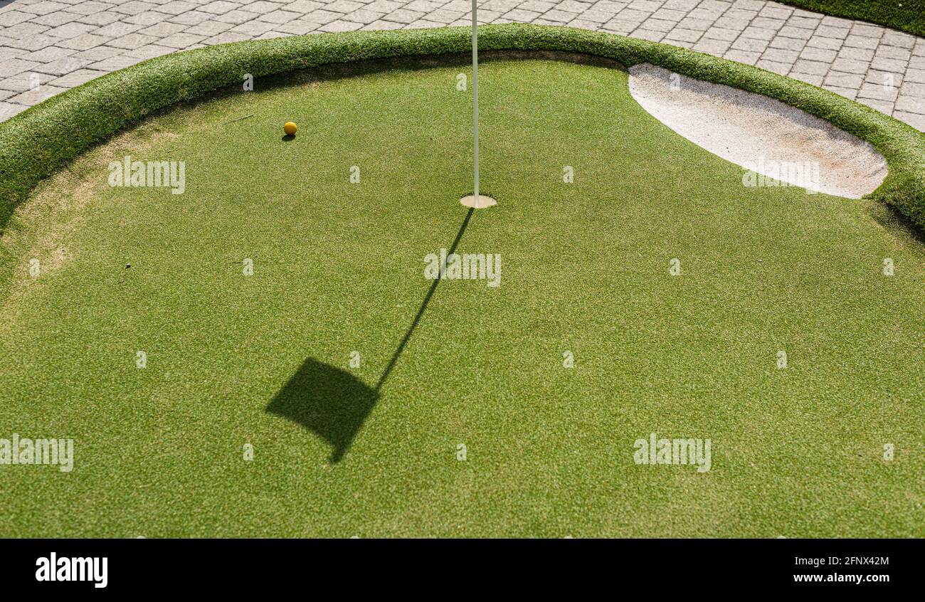 Pin, hole and ball of a minigolf course Stock Photo - Alamy
