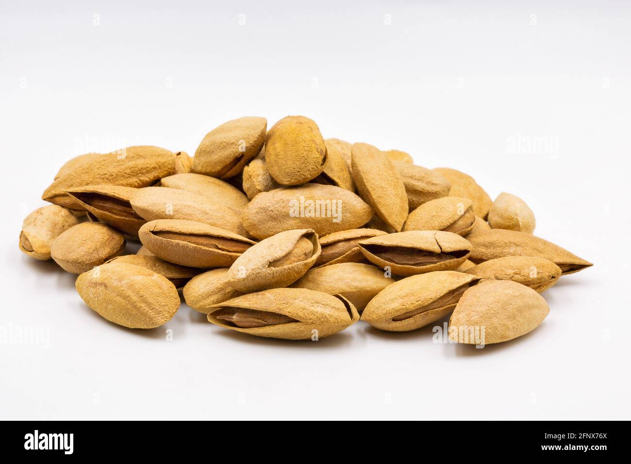 a bunch of selected dried inshell almonds closeup against white ...