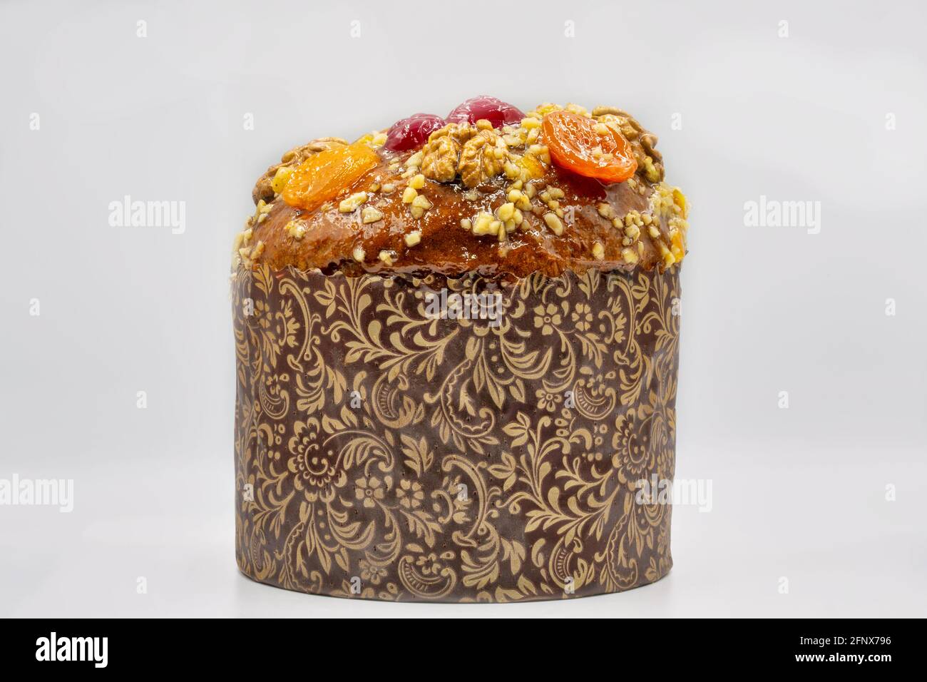 Baked Easter cake with dried apricots and walnuts closeup against white ...