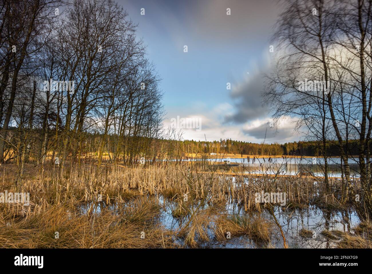 Small woody fishing pier at the lake. Moody colors of sunset. Okuniewo ...