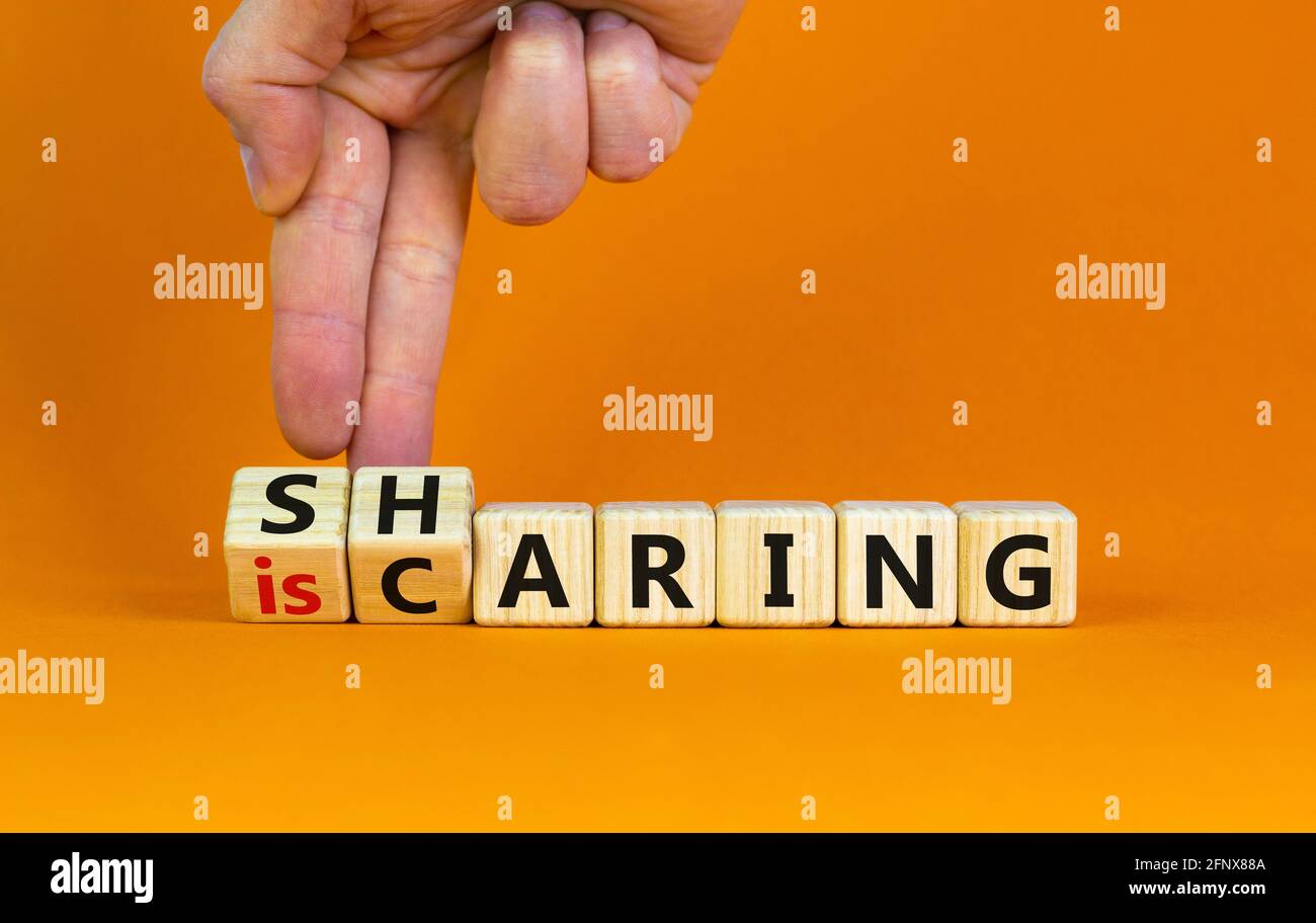Sharing is caring symbol. Businessman turns wooden cubes with words ...