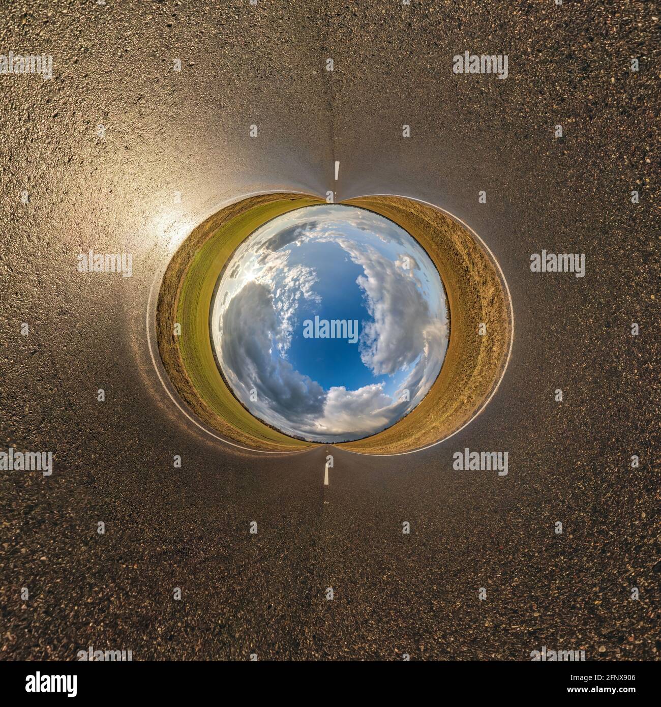 blue sky ball in middle of swirling asphalt road. Inversion of tiny ...