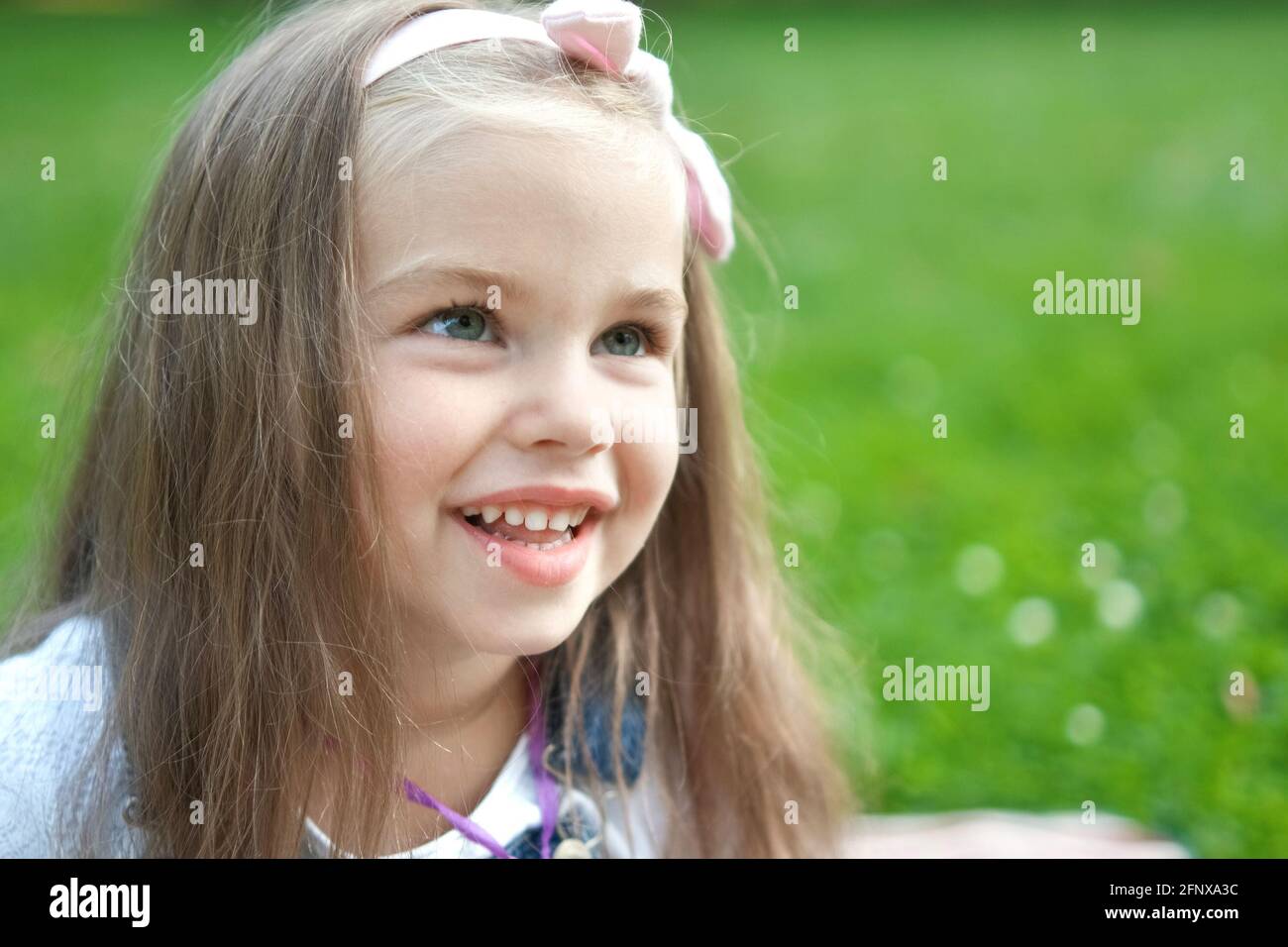 Portrait of pretty child girl in summer park smiling happily Stock ...